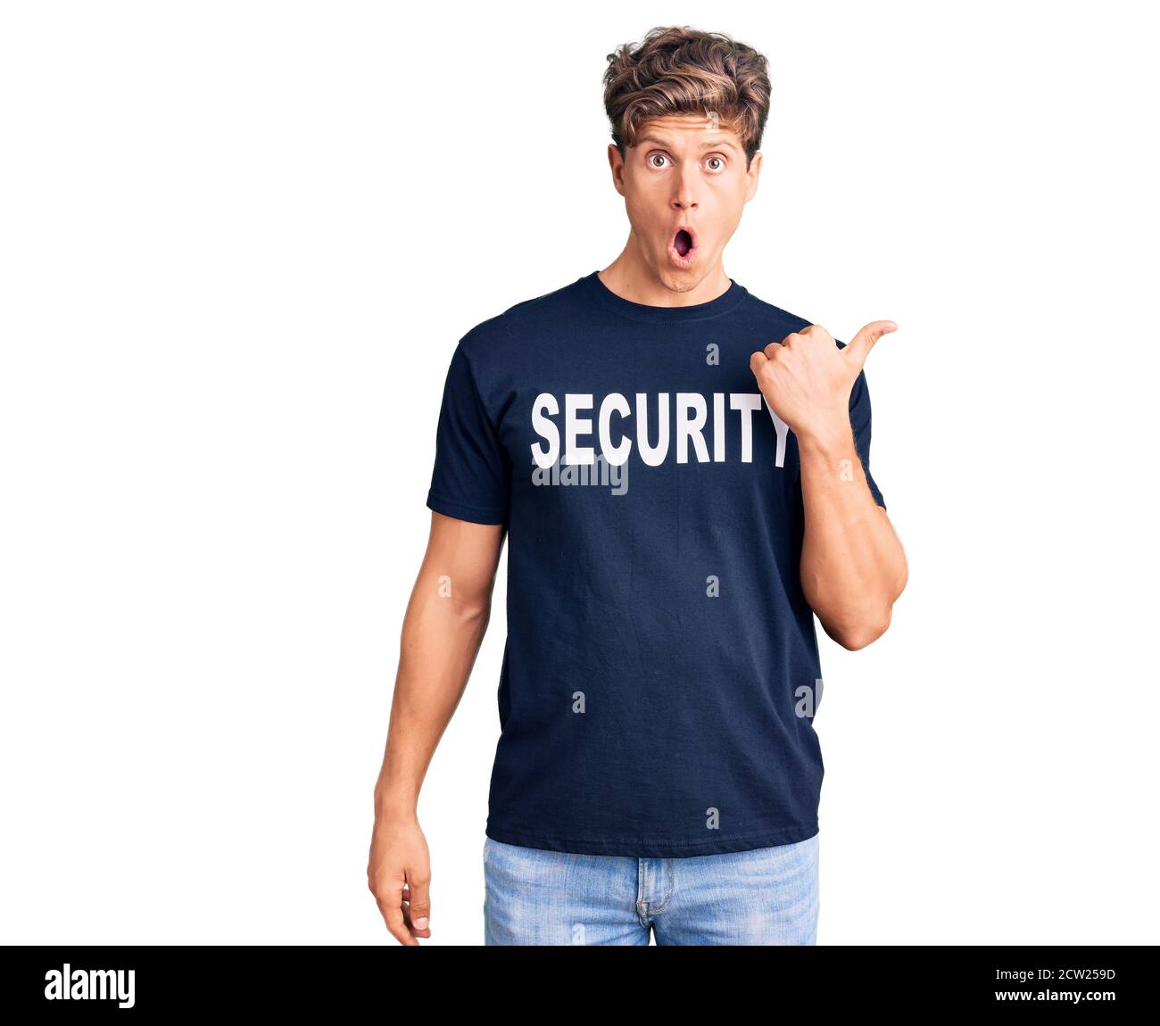 Young handsome man wearing security t shirt surprised pointing with ...