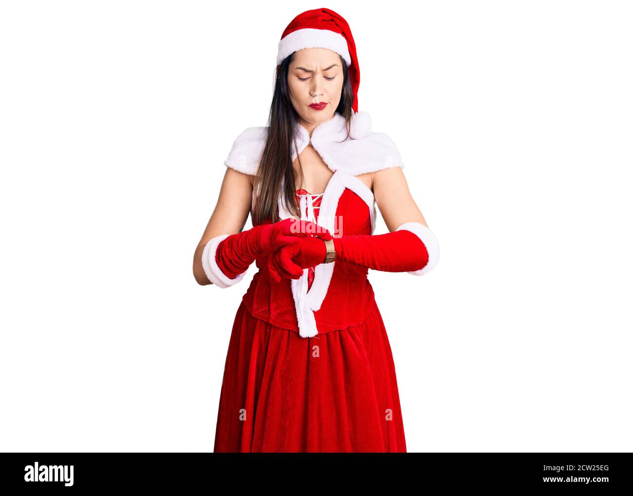 Young beautiful caucasian woman wearing santa claus costume checking ...