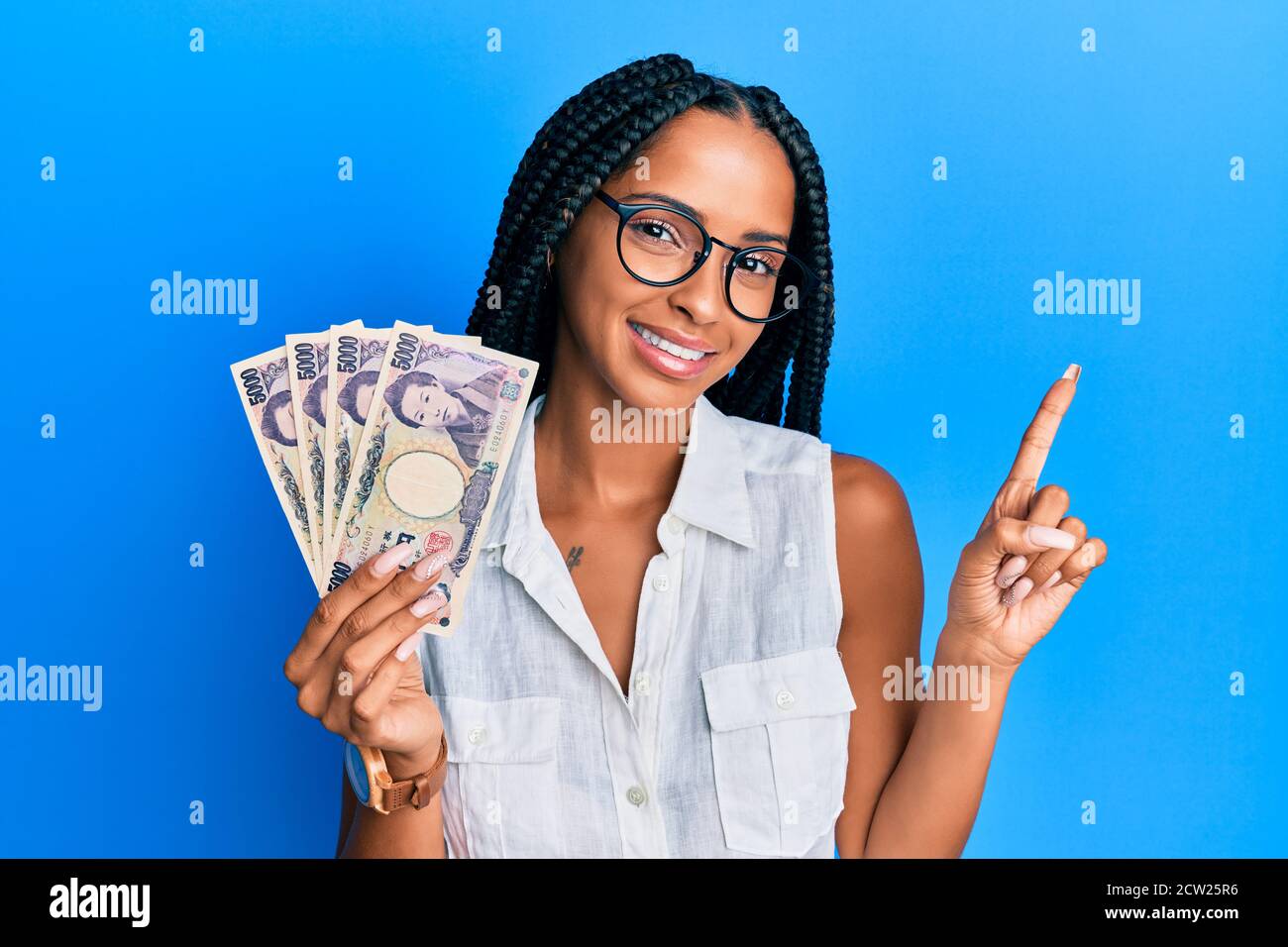 Beautiful hispanic woman holding japanese yen banknotes smiling happy ...