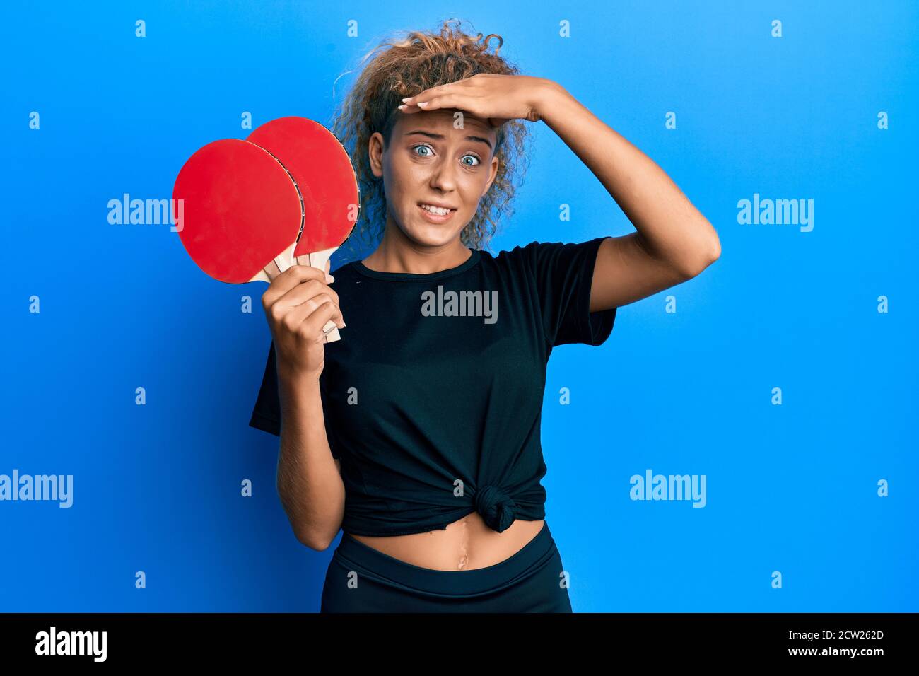 Beautiful caucasian teenager girl holding red ping pong rackets ...