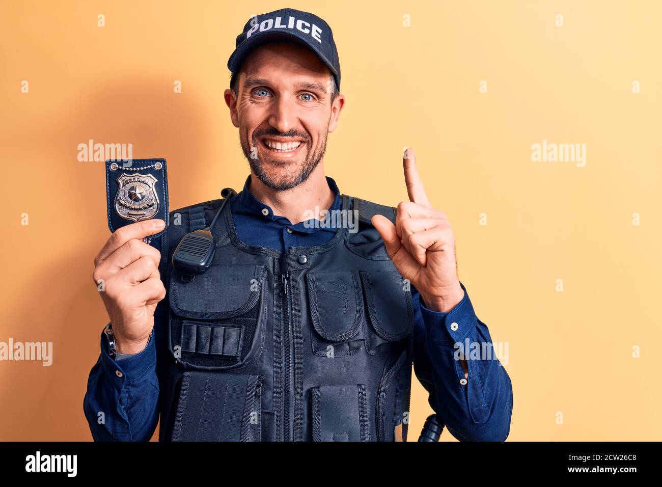 Young handsome policeman wearing uniform and bulletprof holding police ...