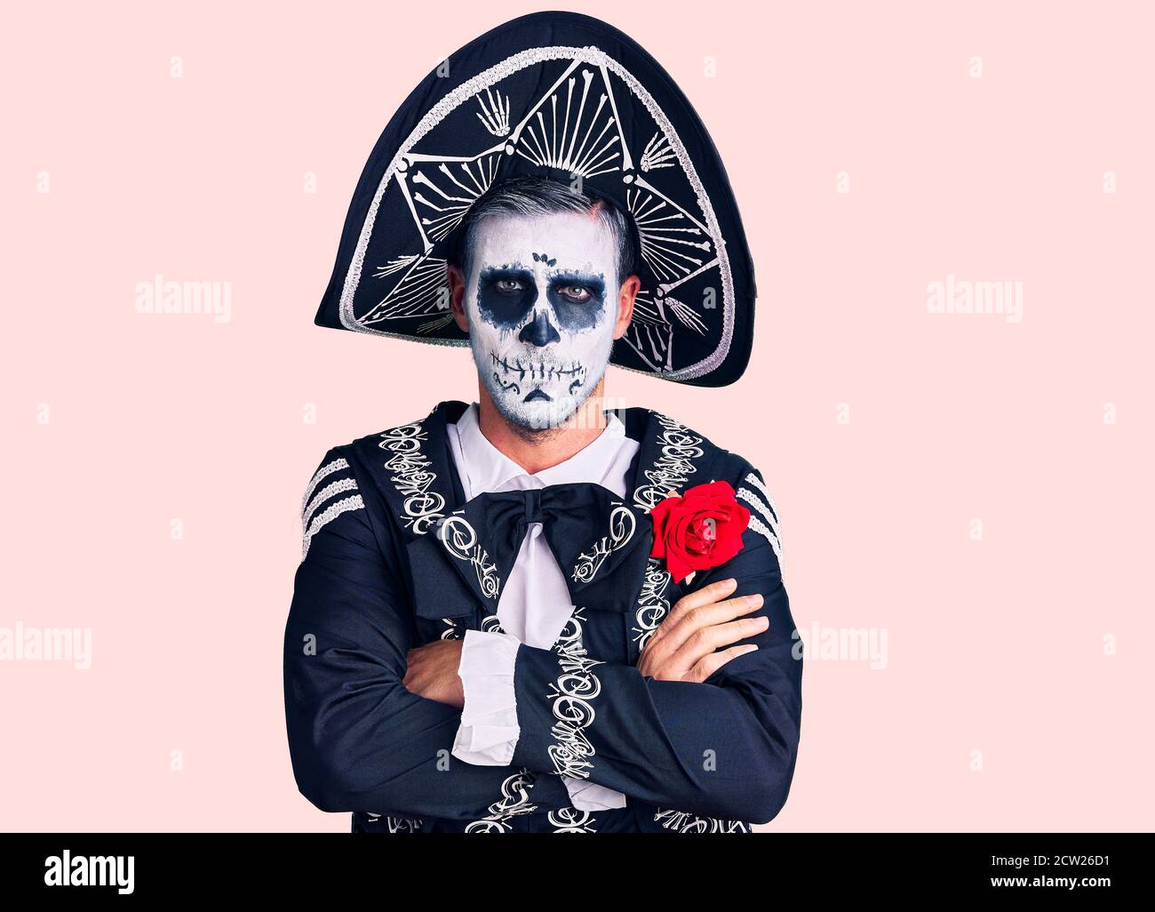 Young man wearing day of the dead costume over background skeptic and ...