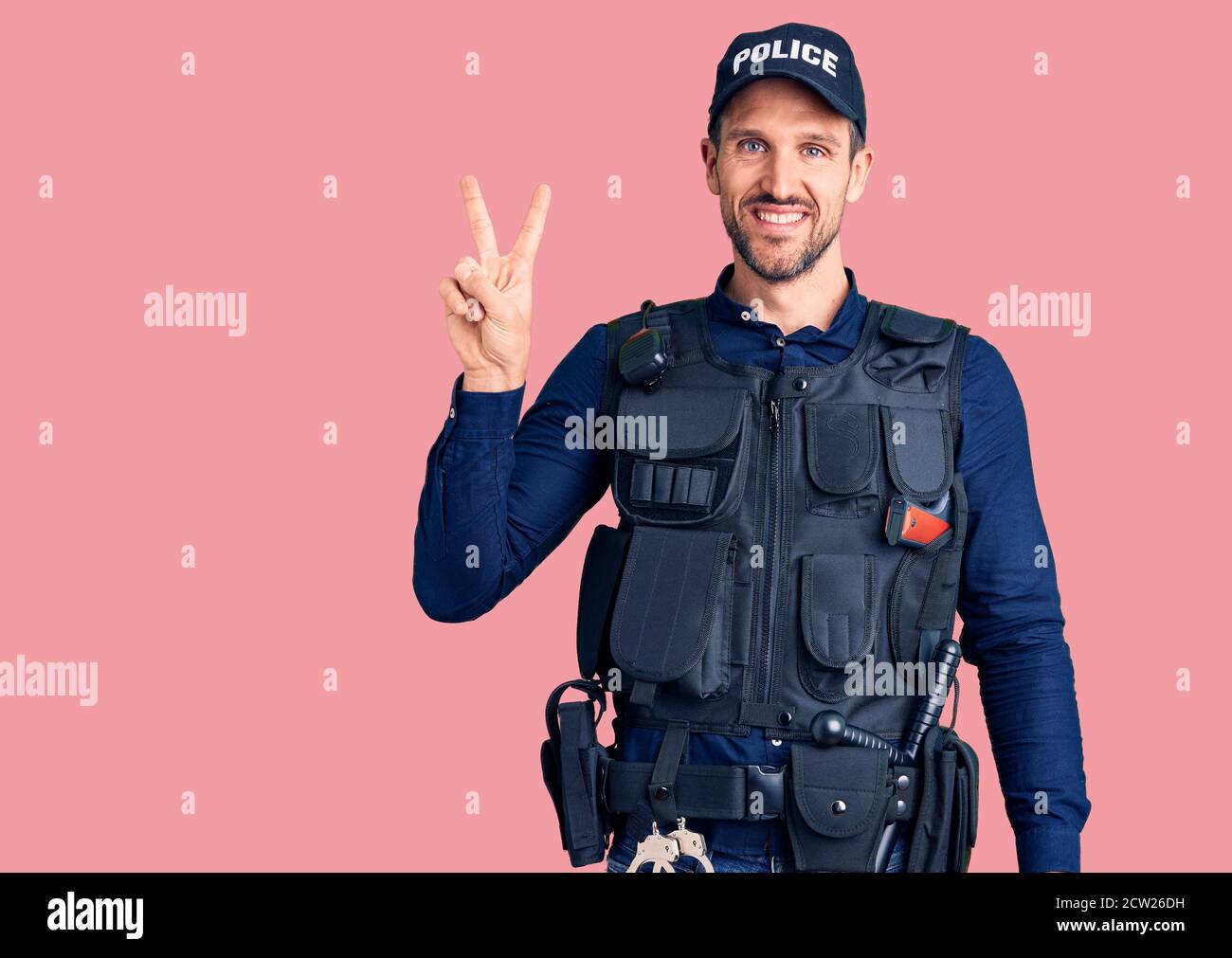 Young handsome man wearing police uniform smiling looking to the camera ...