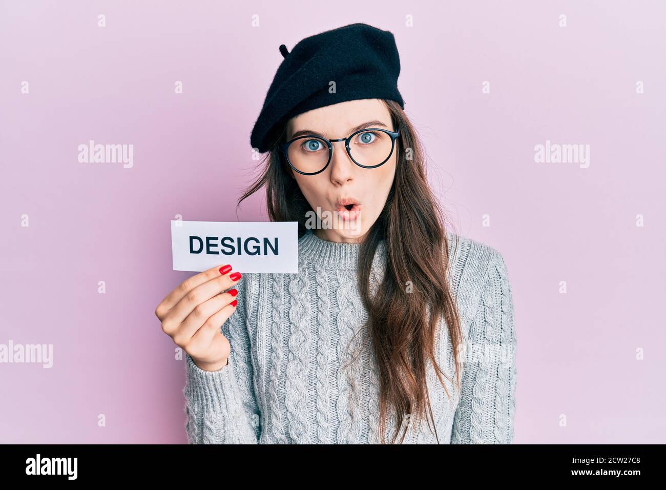 Young beautiful caucasian girl holding design word on paper scared and ...