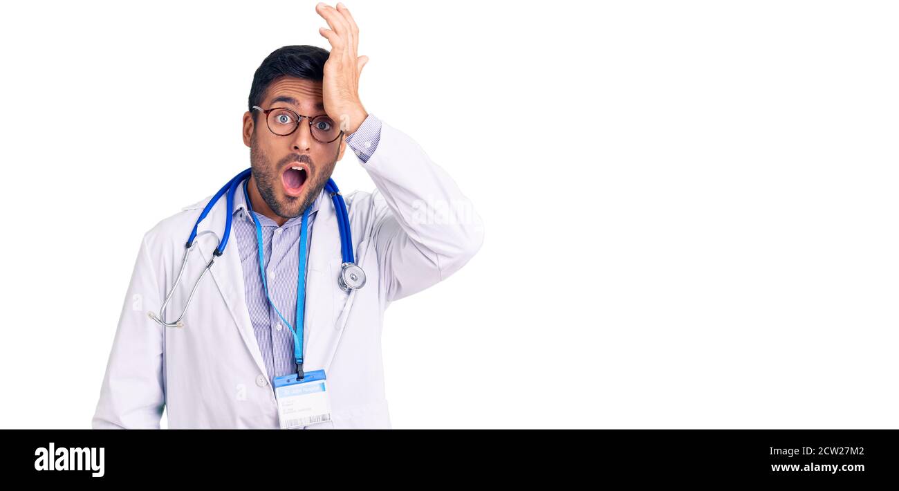 Young hispanic man wearing doctor uniform and stethoscope surprised ...