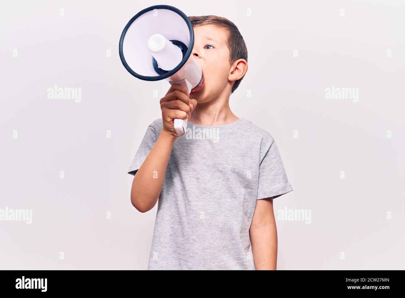 Adorable caucasian kid boy with angry expression. Screaming loud using ...