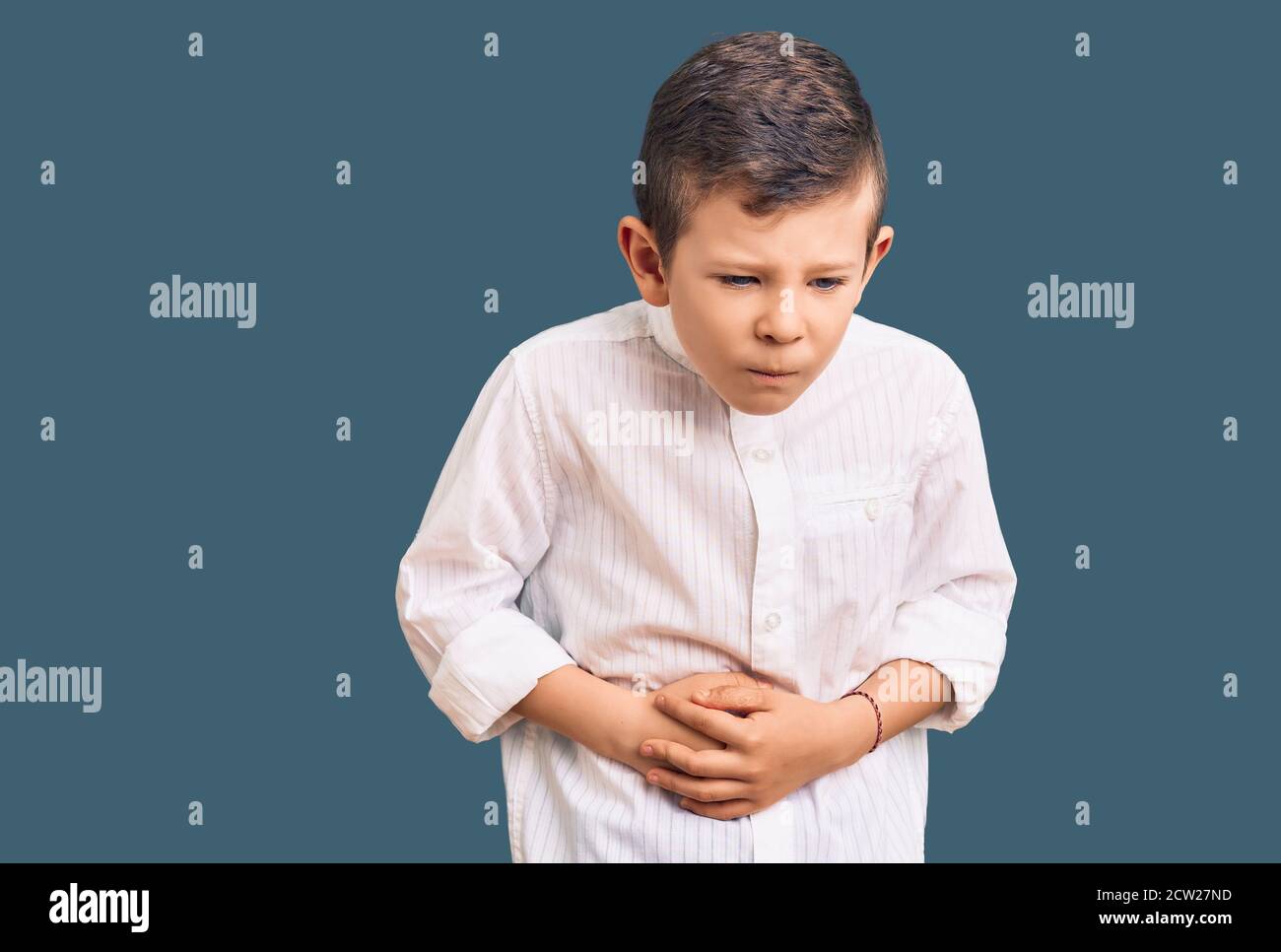 Cute blond kid wearing elegant shirt with hand on stomach because ...