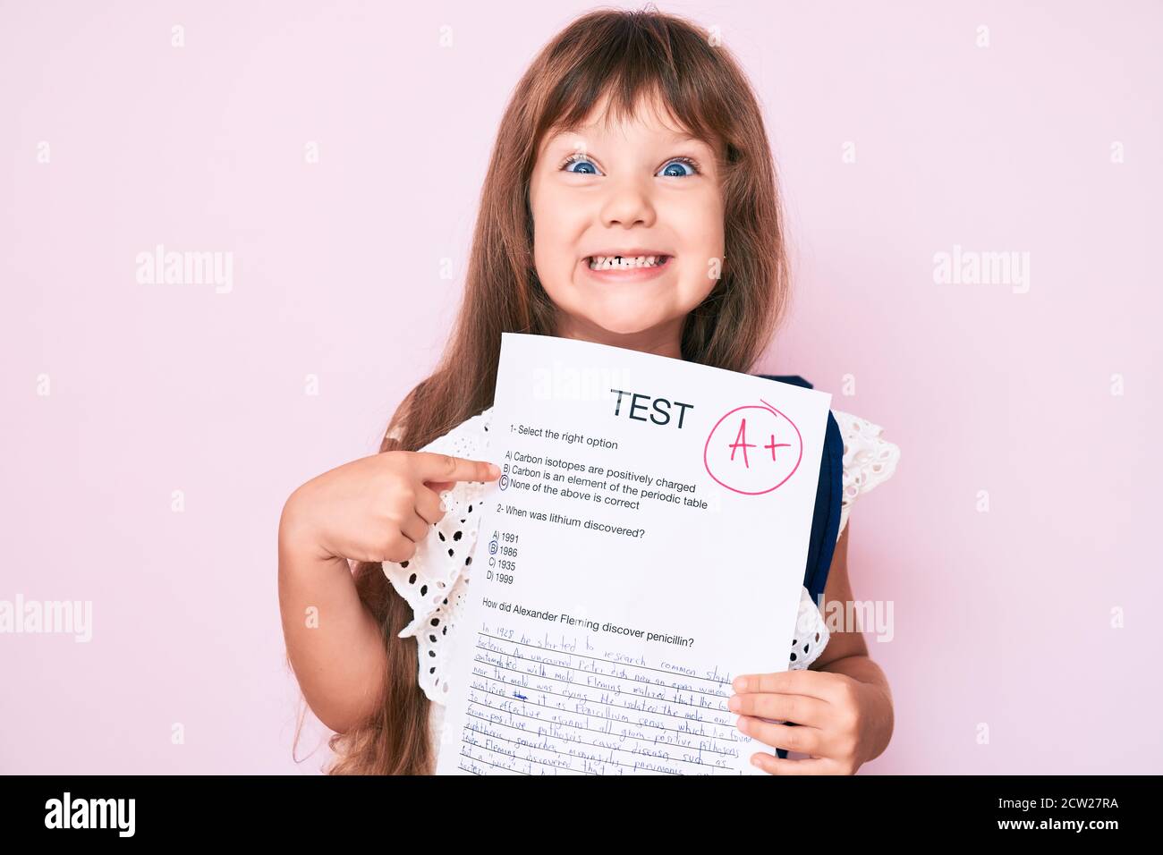 Little caucasian kid girl with long hair showing a passed exam from ...