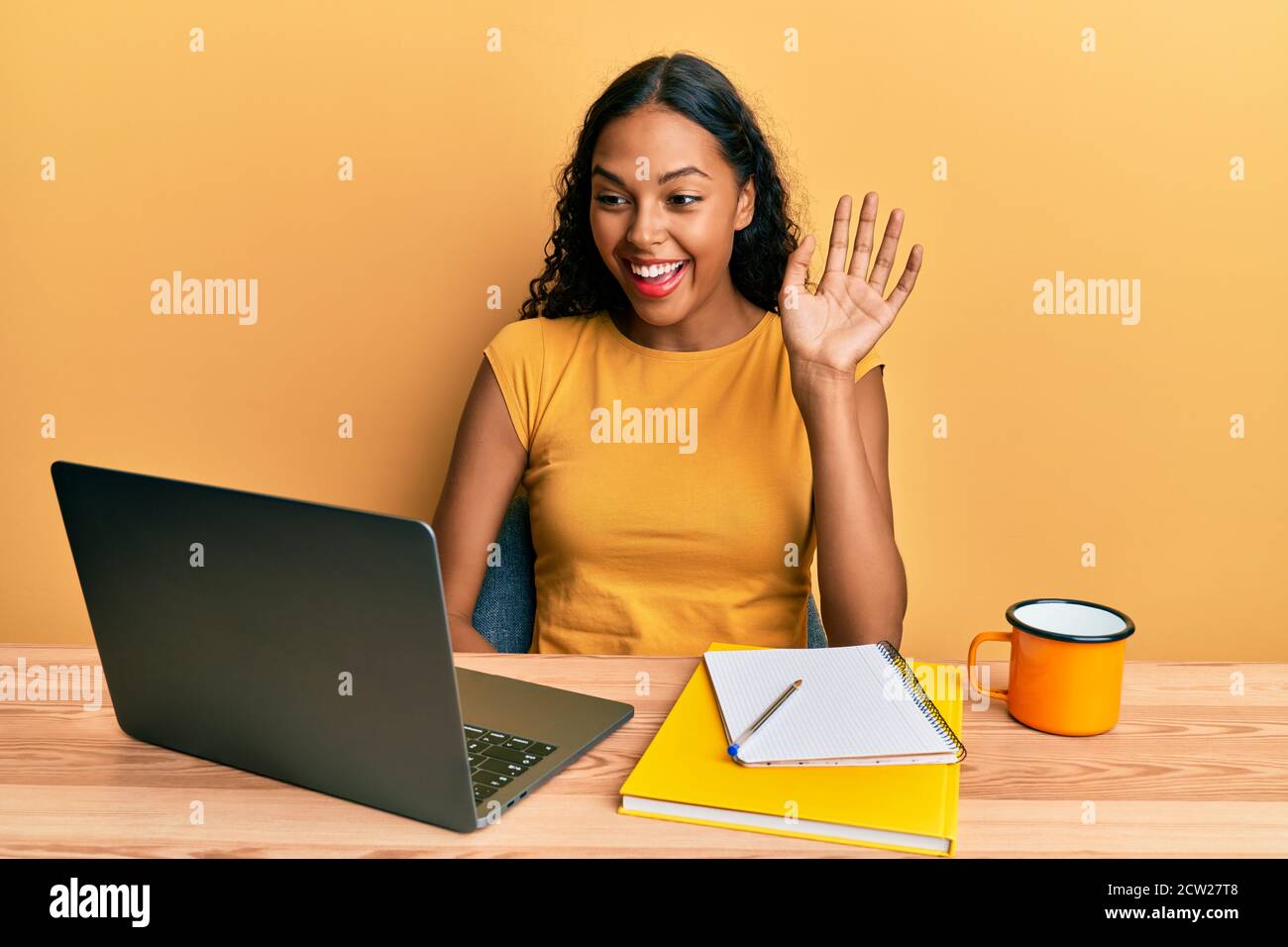 Young african american girl doing video call waving to laptop ...