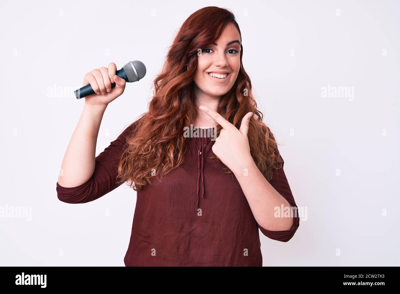 Young beautiful woman singing song using microphone smiling happy ...