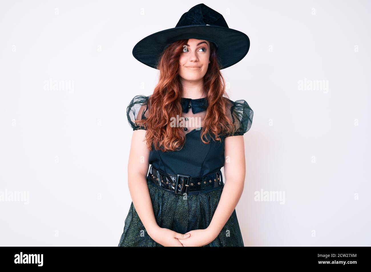 Young beautiful woman wearing witch halloween costume smiling looking ...