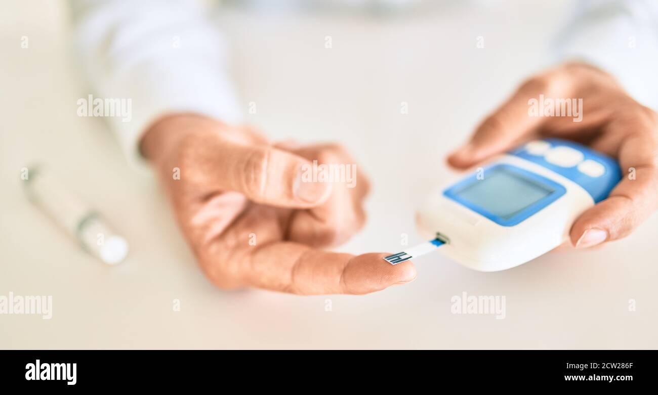 Close up of man with diabetes using insuline glucometer with blood from ...