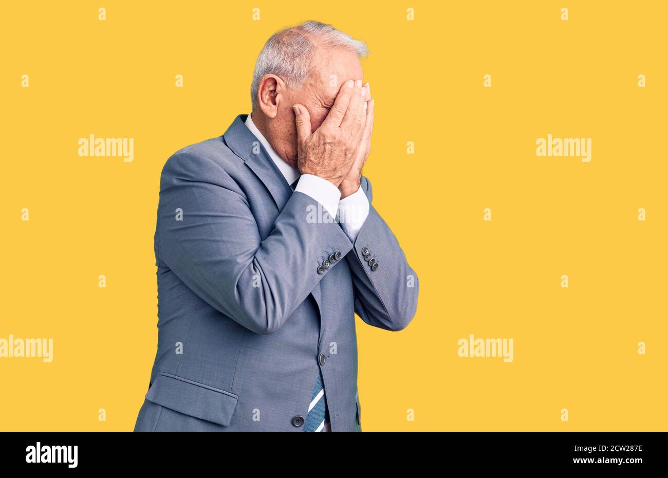 Senior handsome grey-haired man wearing elegant suit with sad ...