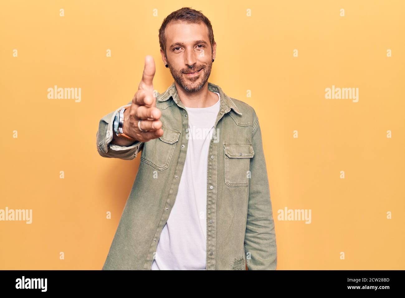 Young handsome man wearing casual clothes smiling friendly offering ...