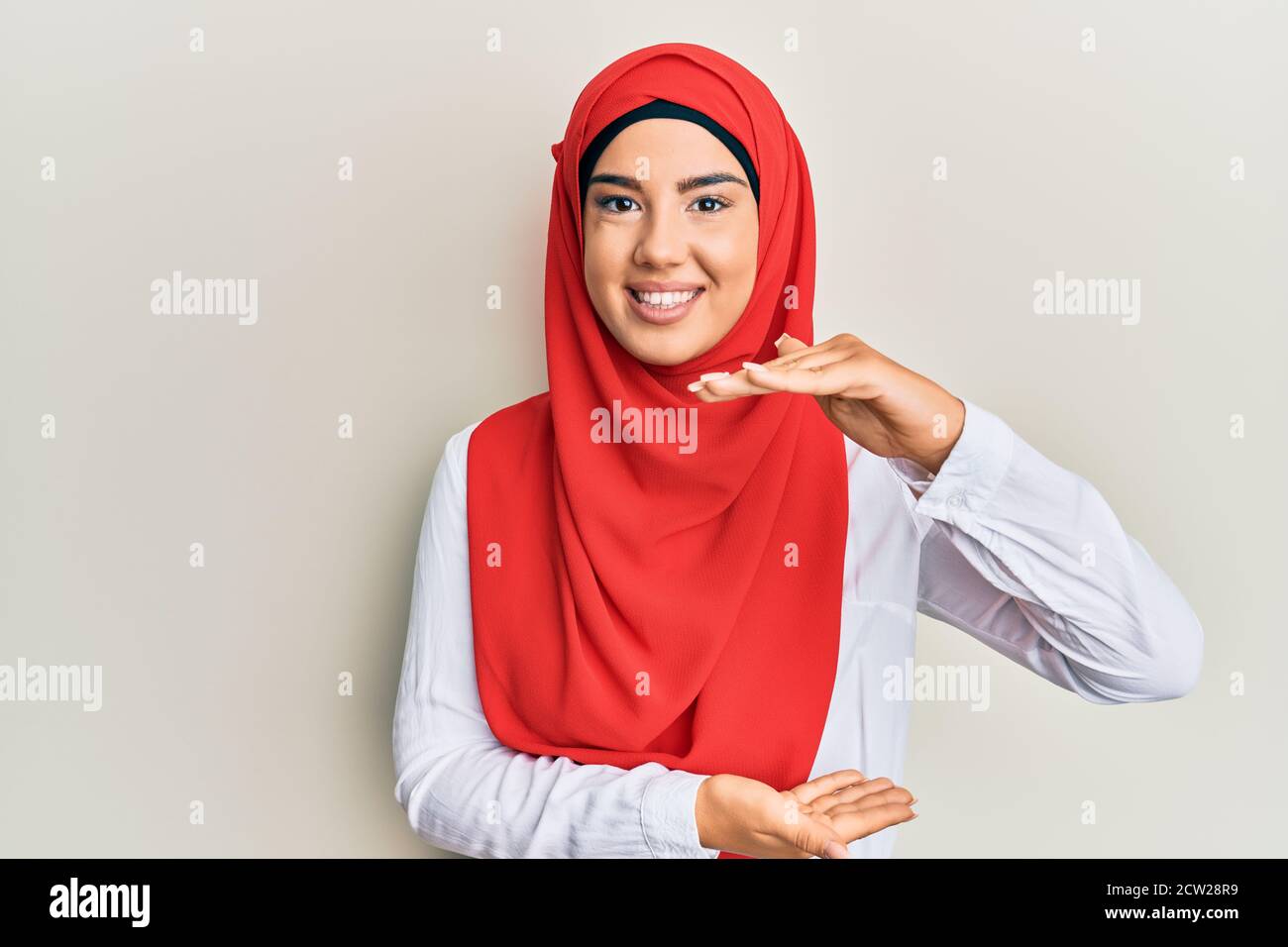 Young beautiful hispanic girl wearing traditional islamic hijab scarf ...