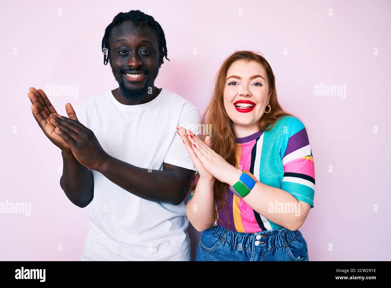Interracial couple wearing casual clothes clapping and applauding happy ...