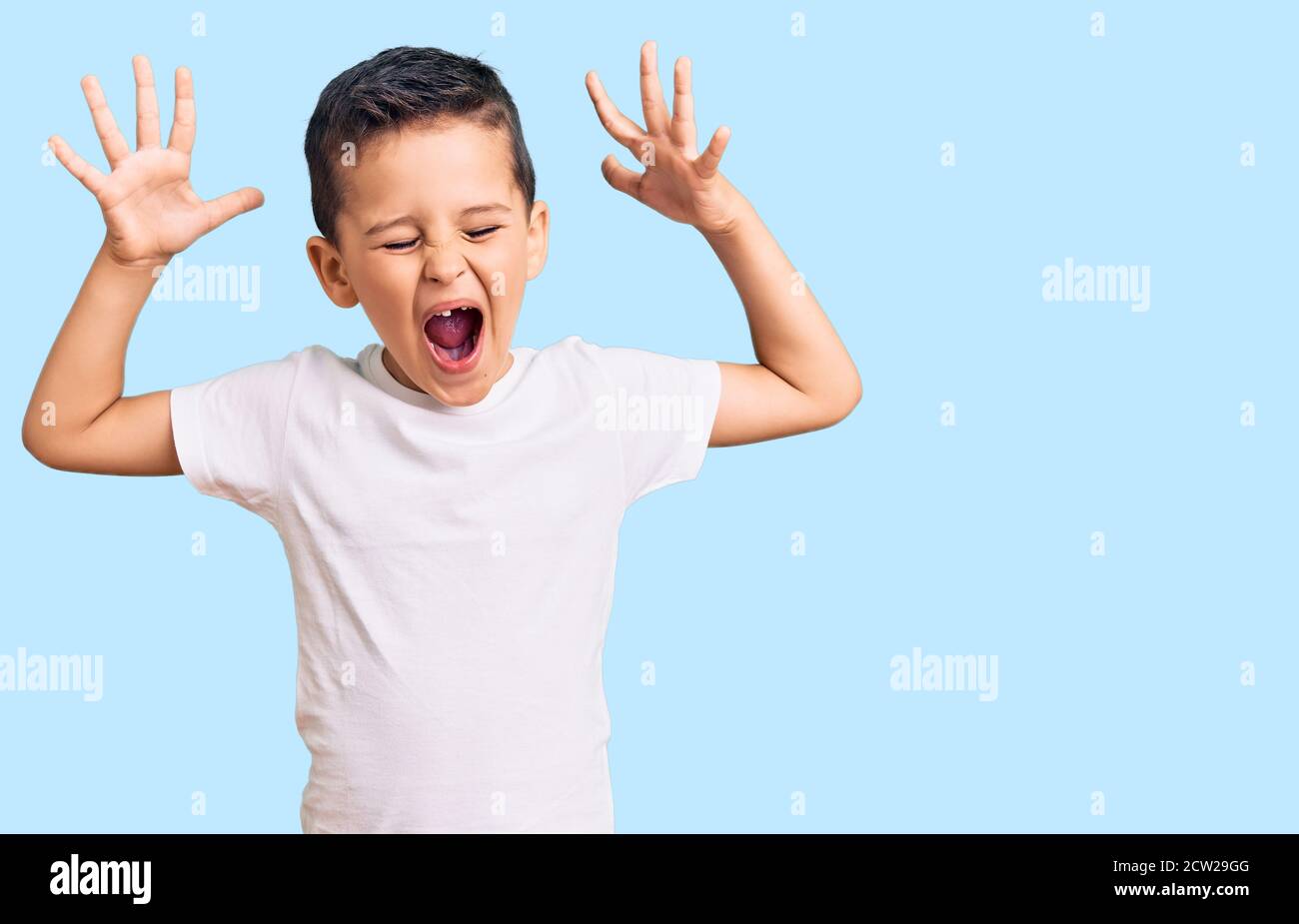 Little cute boy kid wearing casual white tshirt celebrating mad and ...