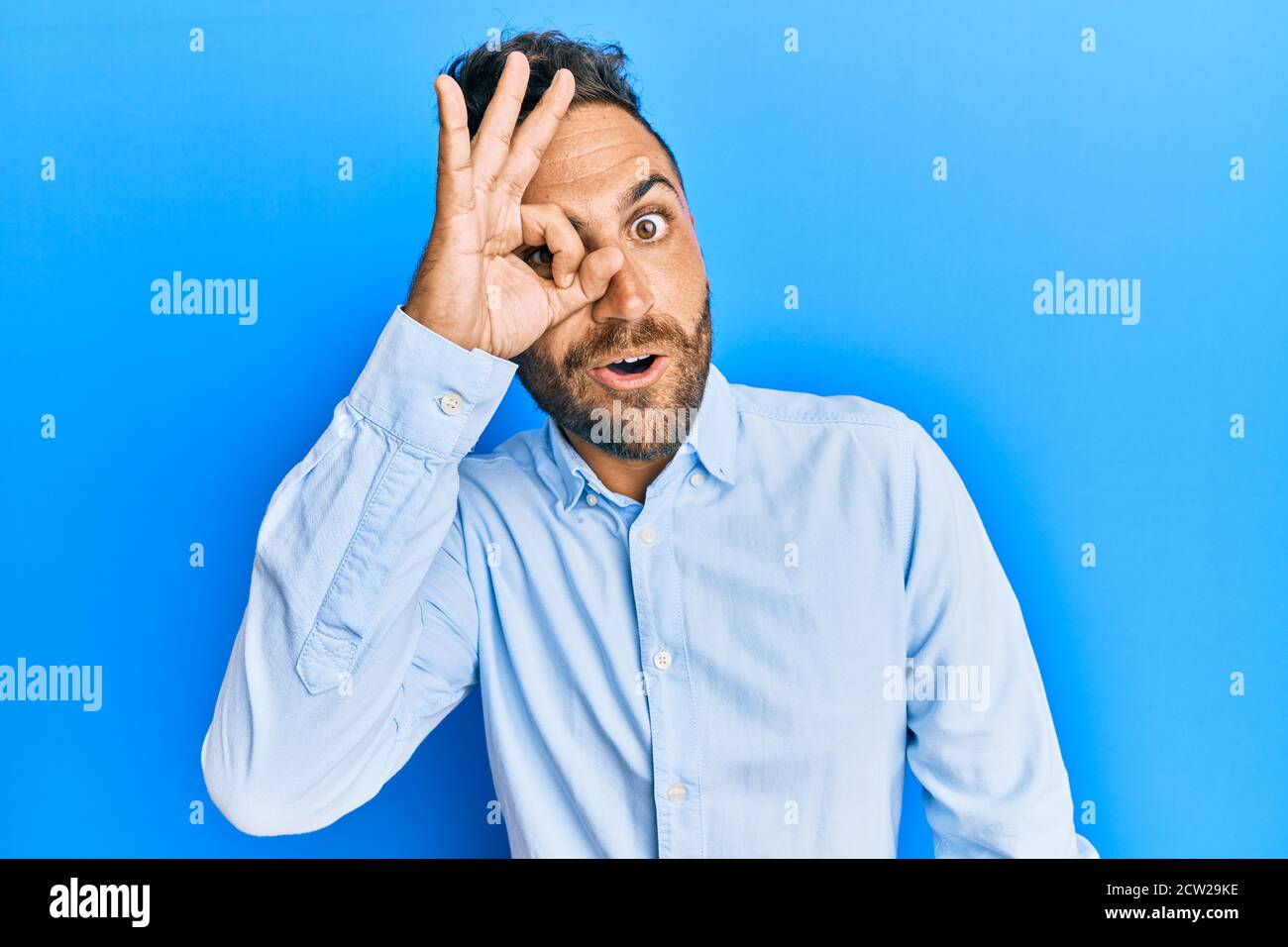 Handsome man with beard wearing casual clothes doing ok gesture shocked ...