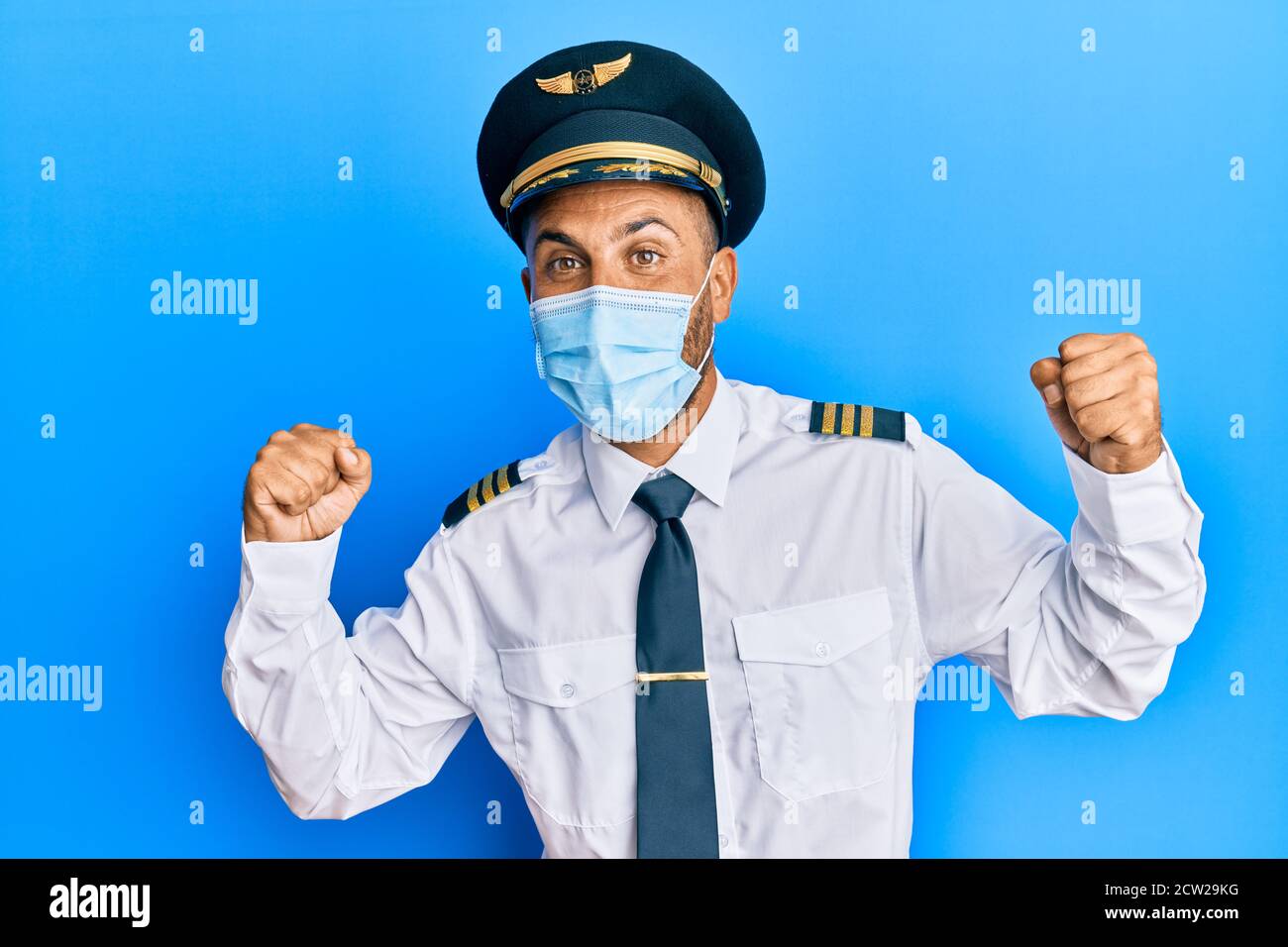 Handsome man with beard wearing airplane pilot uniform wearing safety ...
