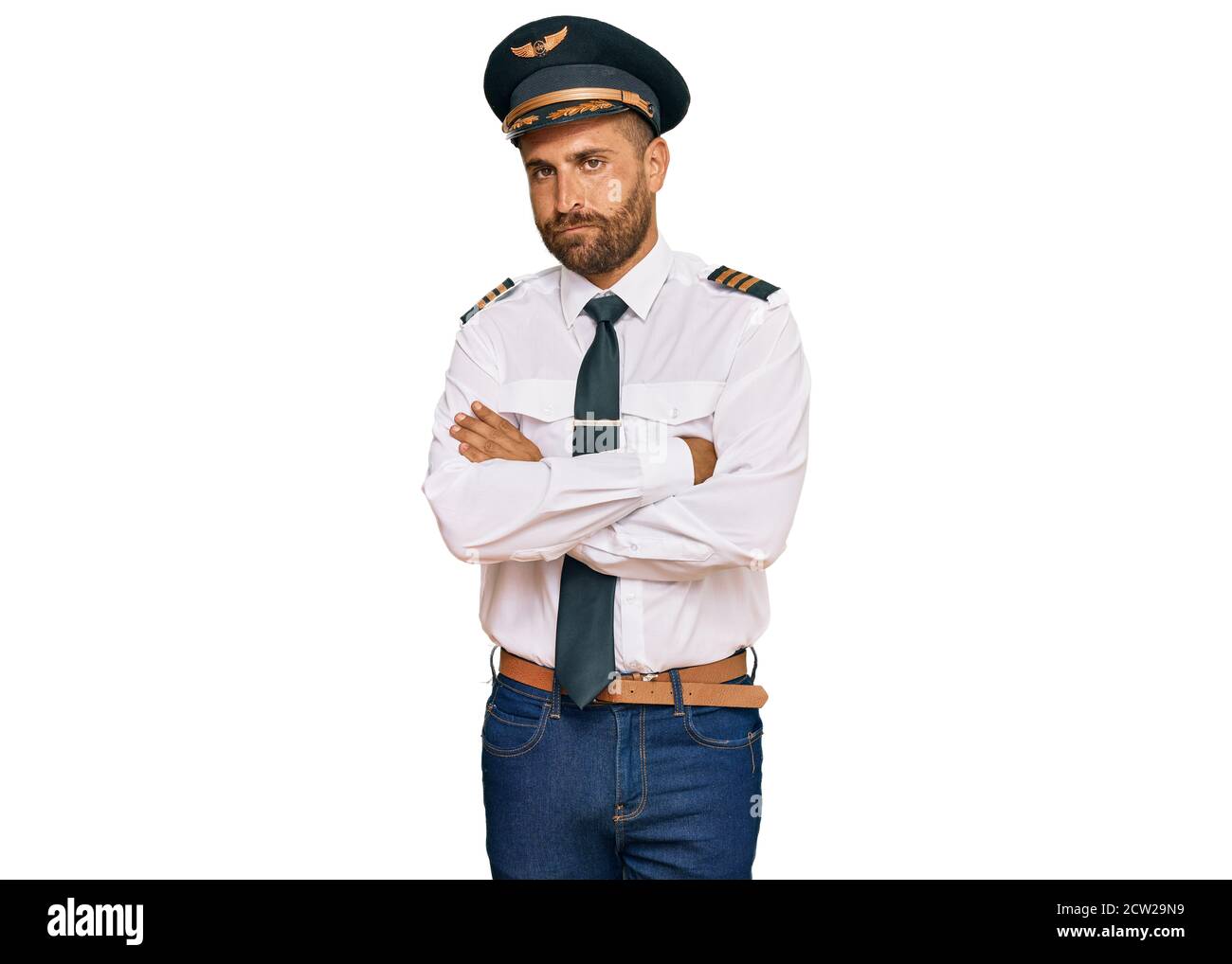 Handsome man with beard wearing airplane pilot uniform skeptic and ...