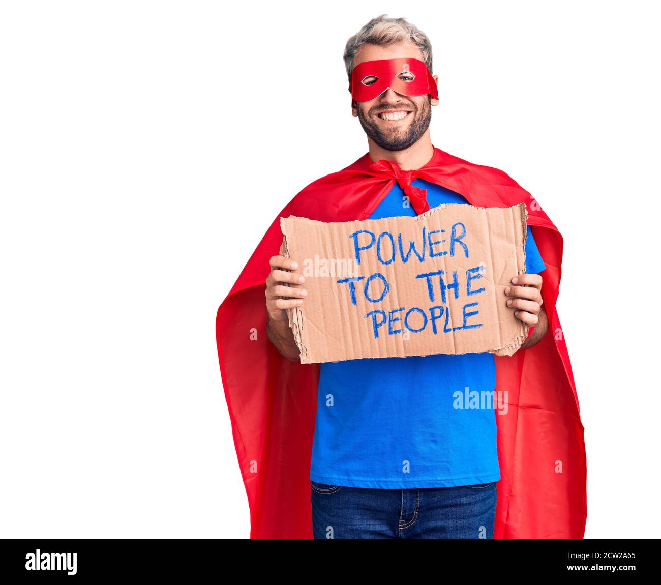 Young blond man wearing super hero custome holding power to the people ...