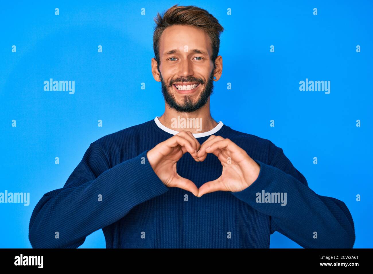 Handsome caucasian man with beard wearing casual sweater smiling in ...