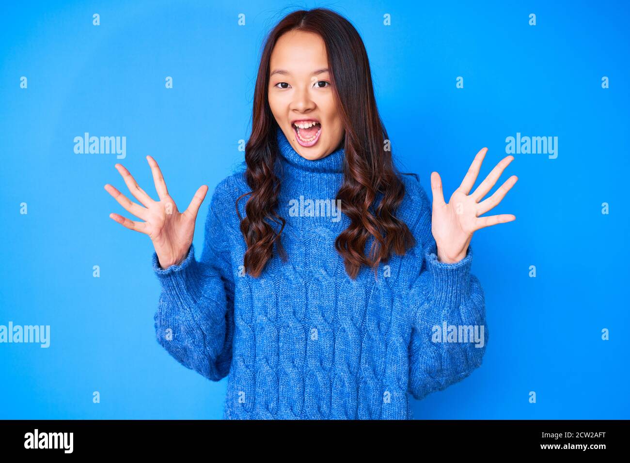 Young beautiful chinese girl wearing casual winter sweater celebrating ...