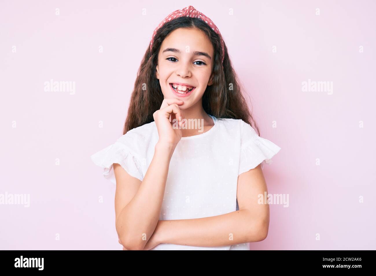 Cute hispanic child girl wearing casual clothes and diadem looking ...