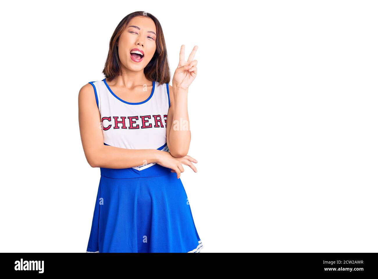 Young beautiful chinese girl wearing cheerleader uniform smiling with ...