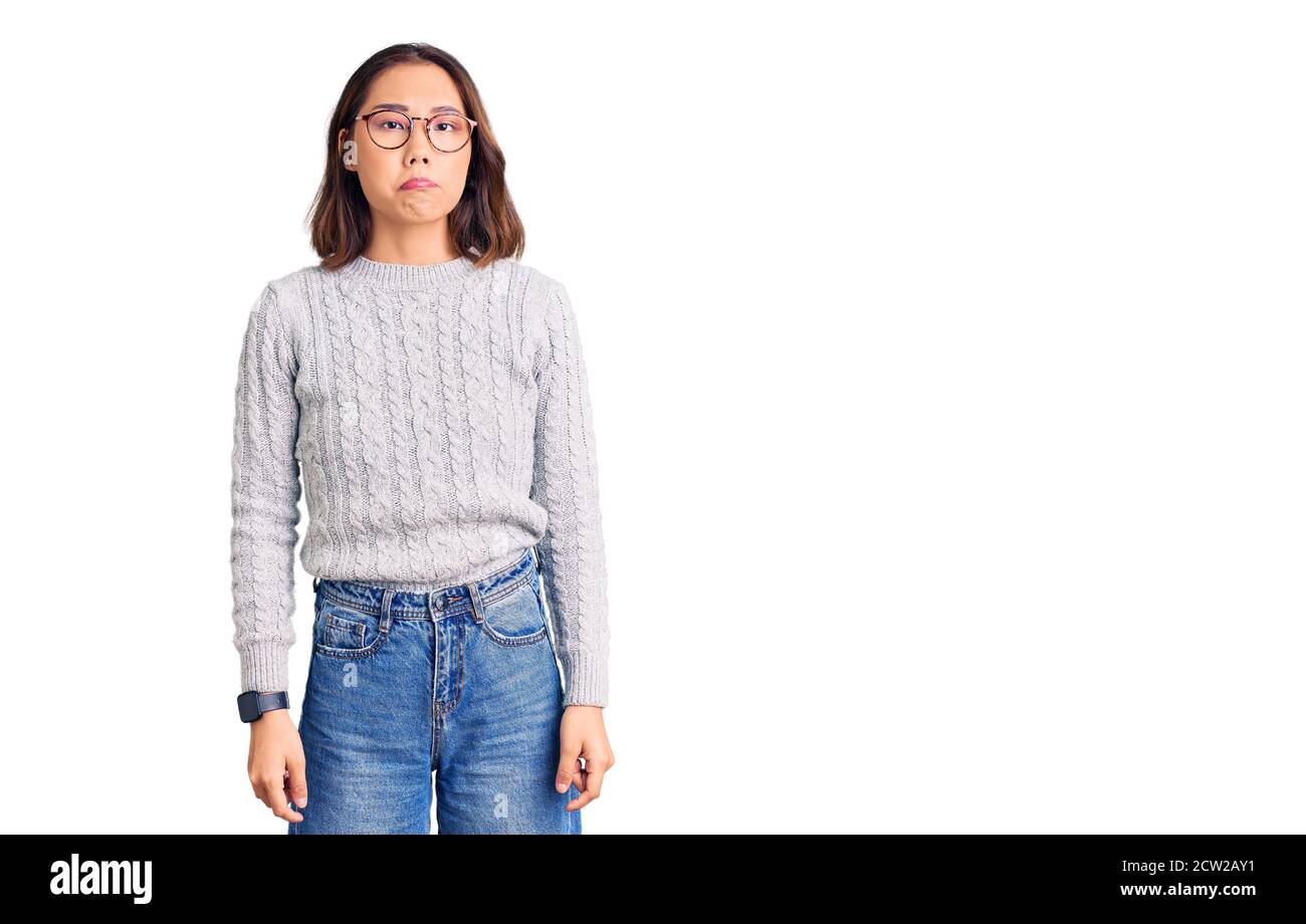 Young beautiful chinese girl wearing casual clothes depressed and worry ...