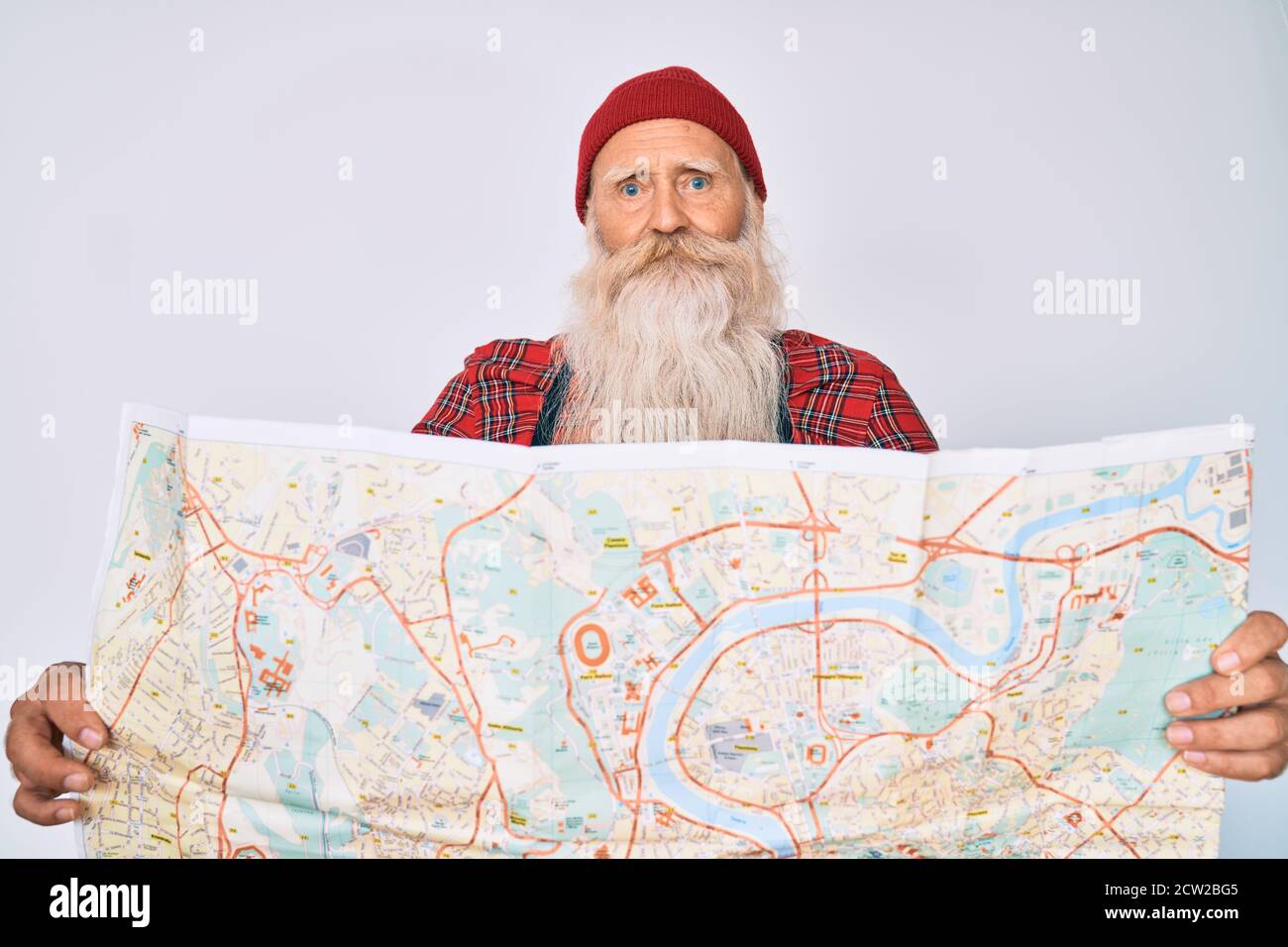 Old senior man with grey hair and long beard holding city map relaxed ...