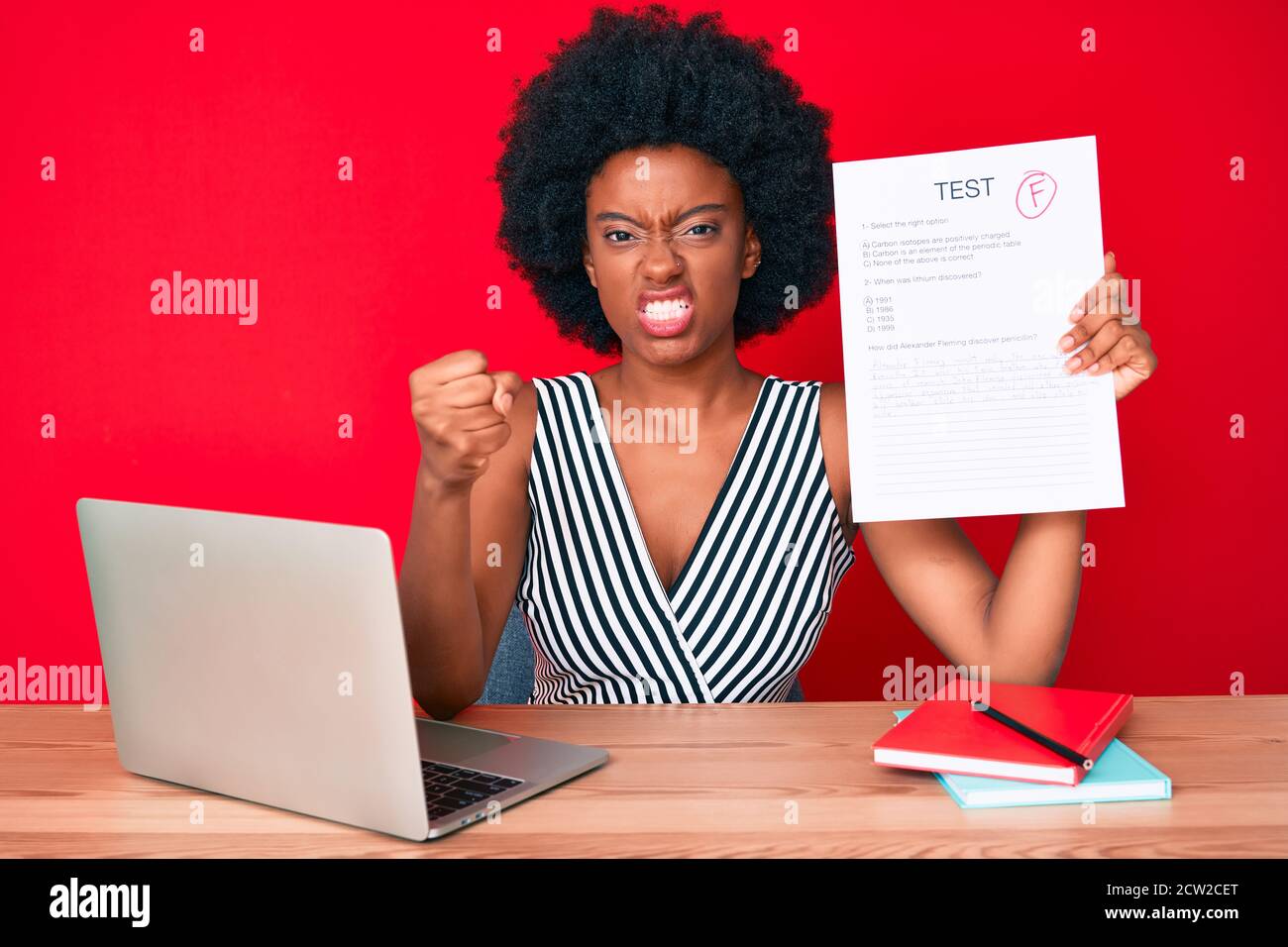 Young african american woman showing a failed exam annoyed and ...