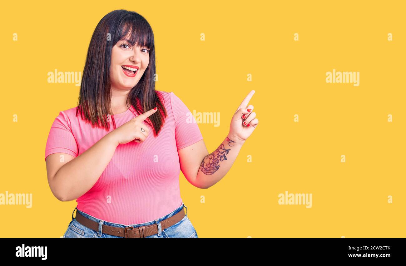 Young plus size woman wearing casual clothes smiling and looking at the ...