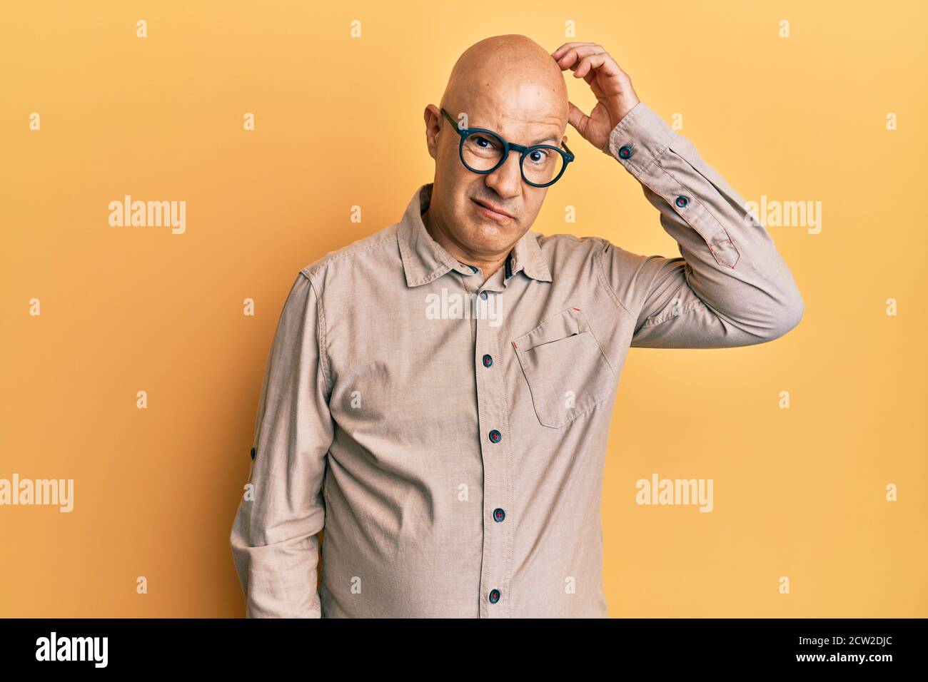 Middle age bald man wearing casual clothes and glasses confuse and ...