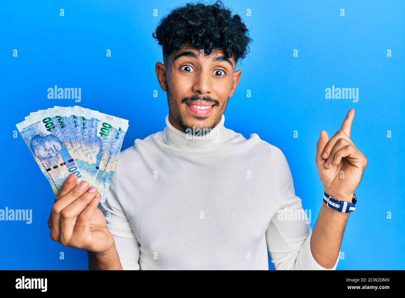 Young arab handsome man holding south african 100 rand banknotes ...