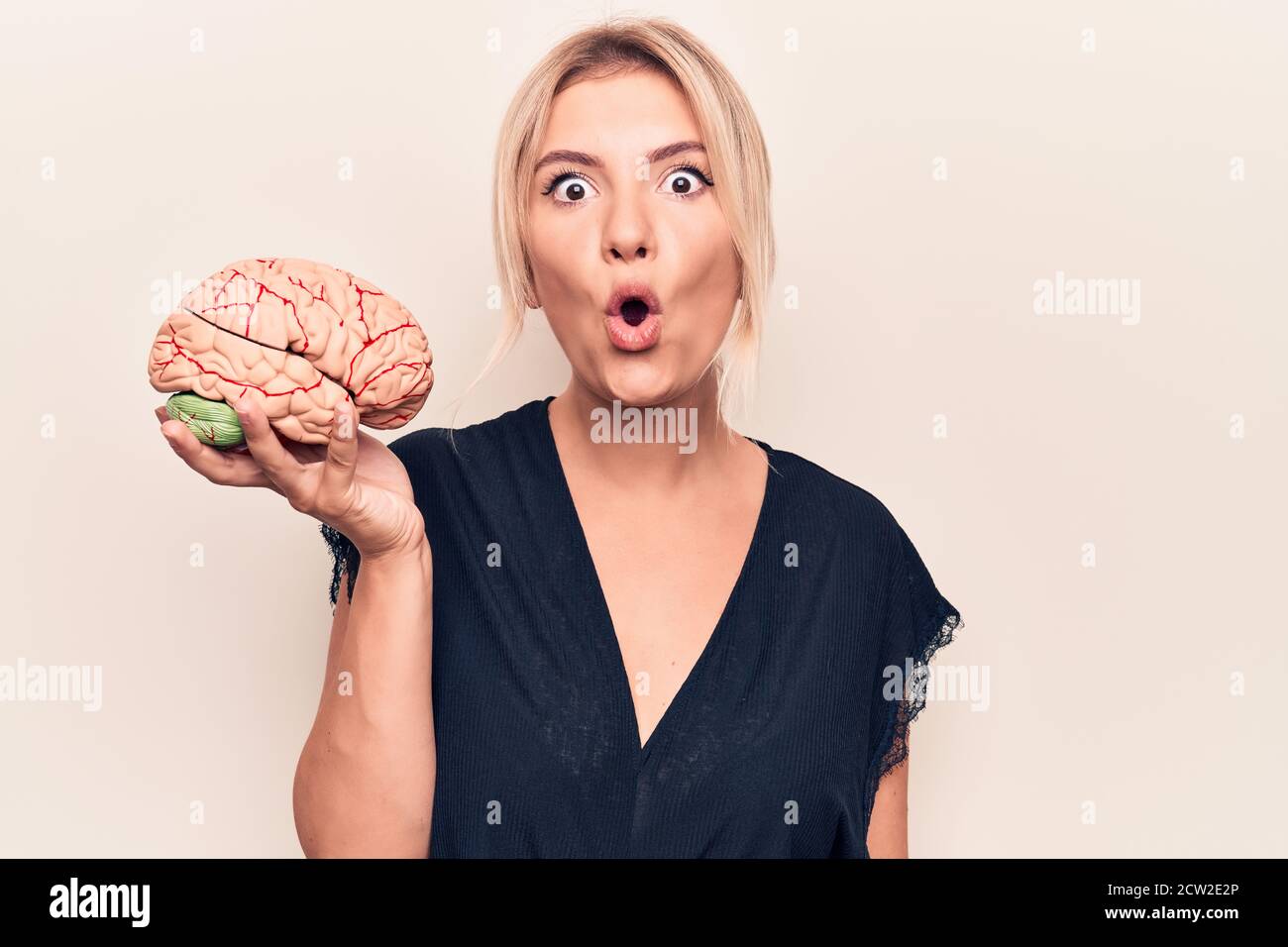 Young beautiful blonde woman asking for care memory holding brain over ...