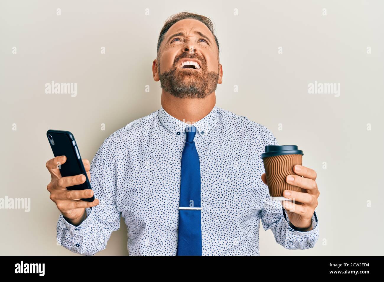 Handsome middle age business man using smartphone and drinking a cup of ...