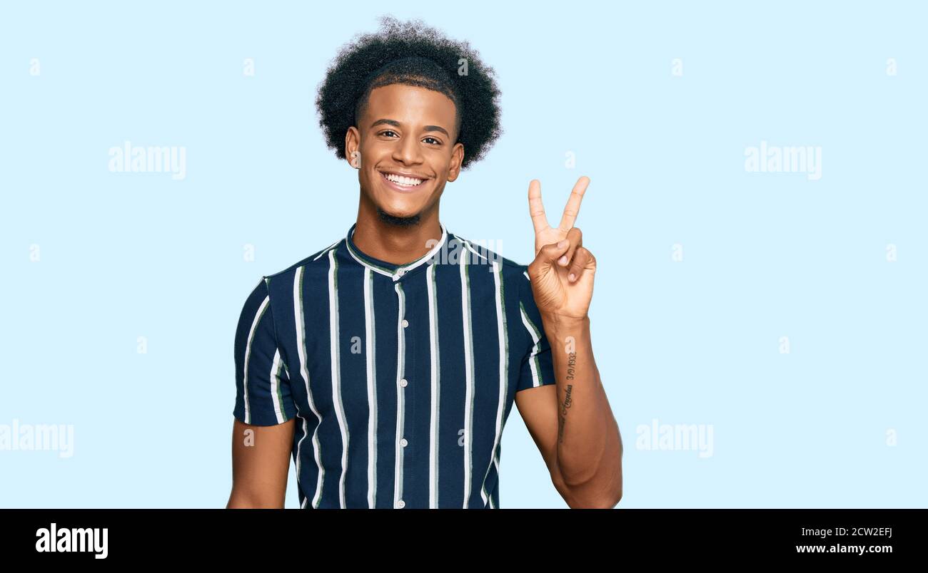 African american man with afro hair wearing casual clothes showing and ...