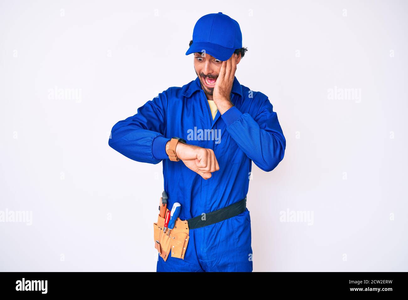 Handsome young man with curly hair and bear weaing handyman uniform ...