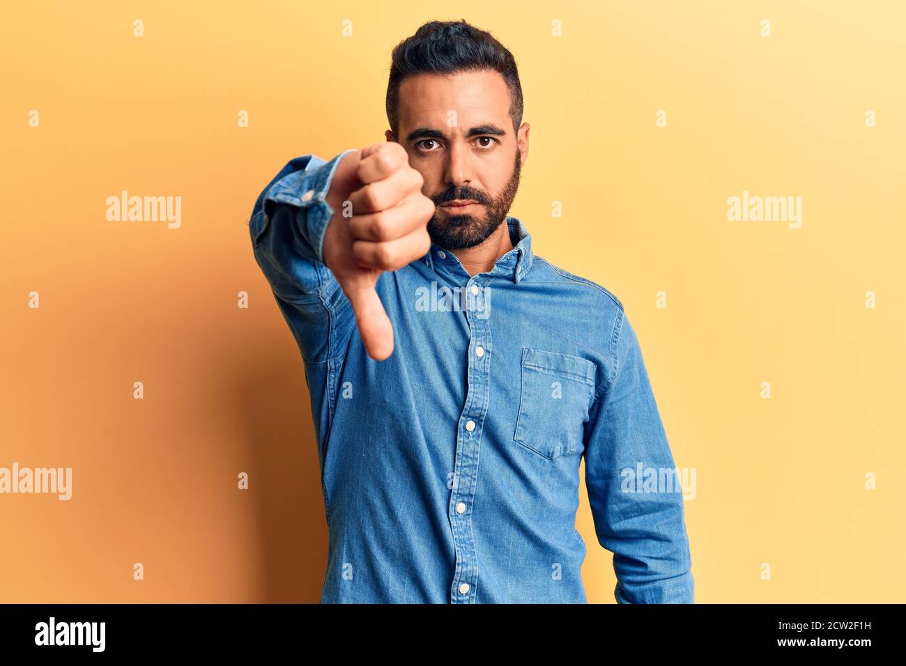 Young hispanic man wearing casual clothes looking unhappy and angry ...