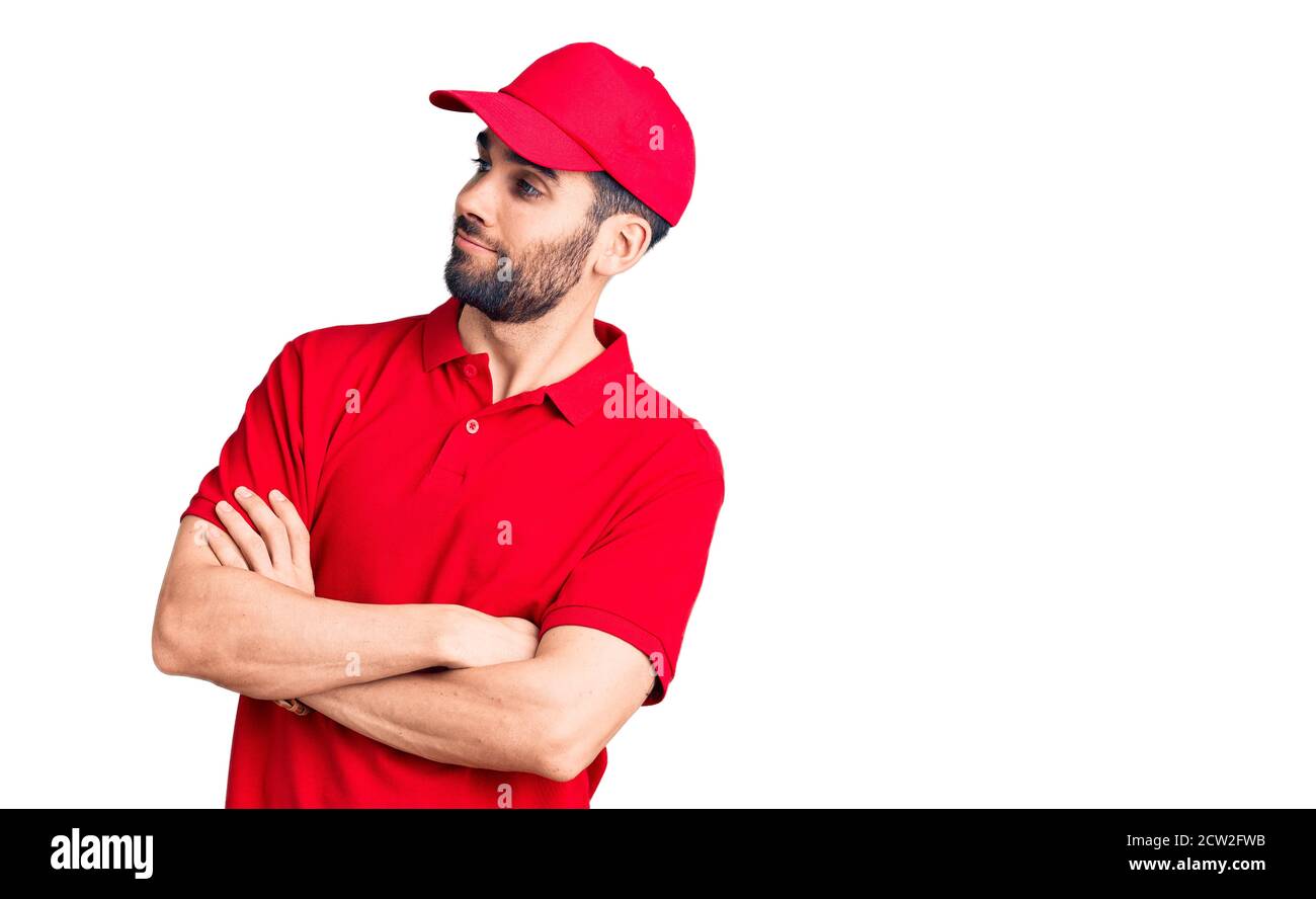 Young Handsome Man With Beard Wearing Delivery Uniform Looking To The