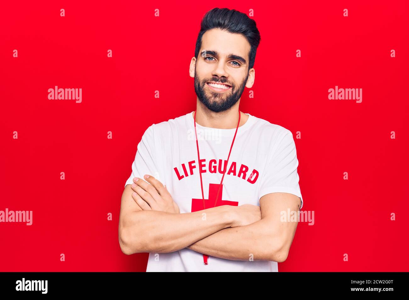 Young handsome man with beard wearing lifeguard t-shirt and whistle ...