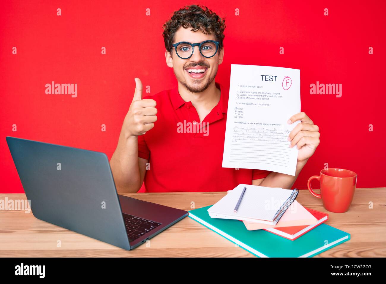 Young caucasian man with curly hair sitting on the table showing failed ...