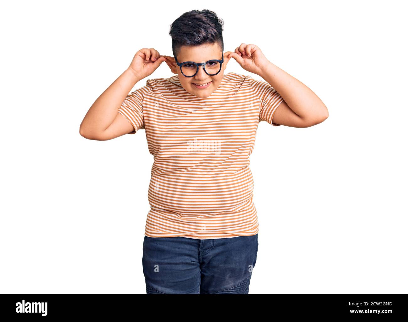 Little boy kid wearing casual clothes and glasses smiling pulling ears ...