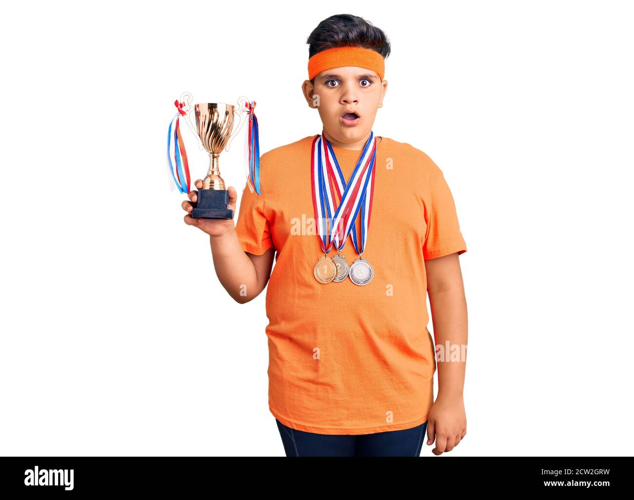 Little boy kid holding champion trophy and wearing medals scared and ...