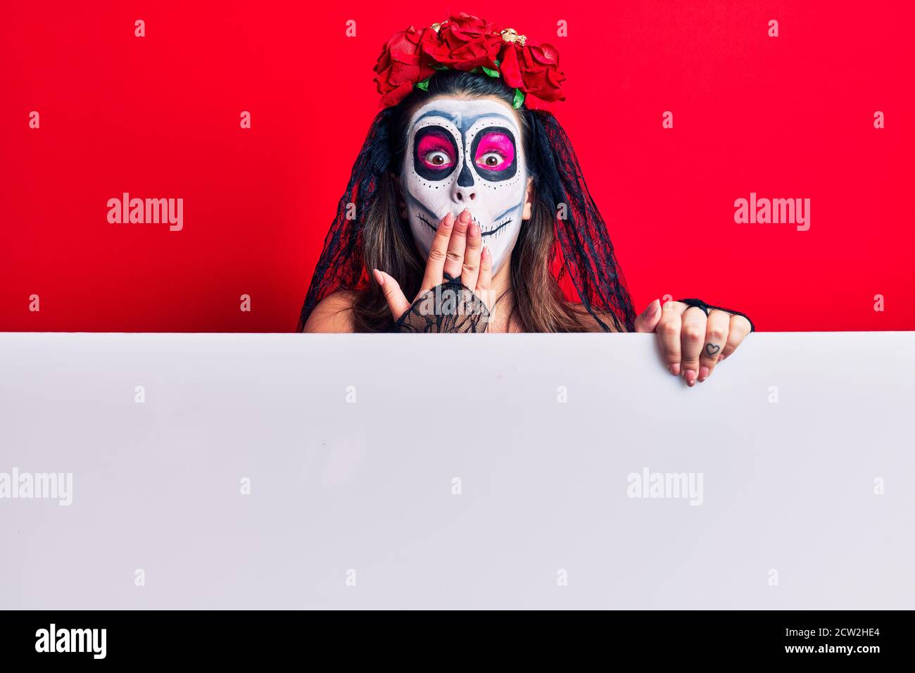 Young woman wearing day of the dead costume holding blank empty banner ...