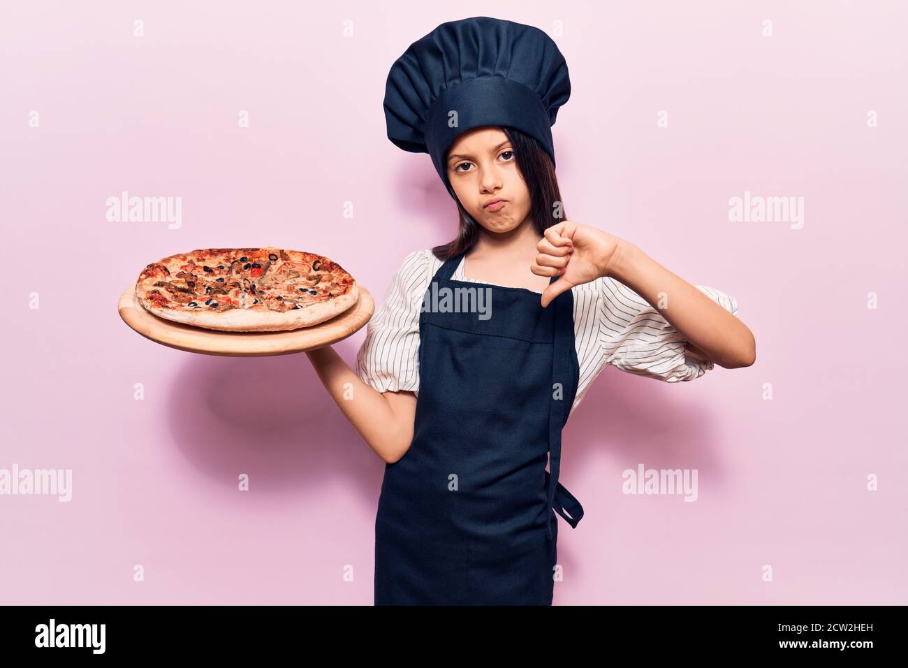 Beautiful child girl wearing cooker uniform holding italian pizza with ...