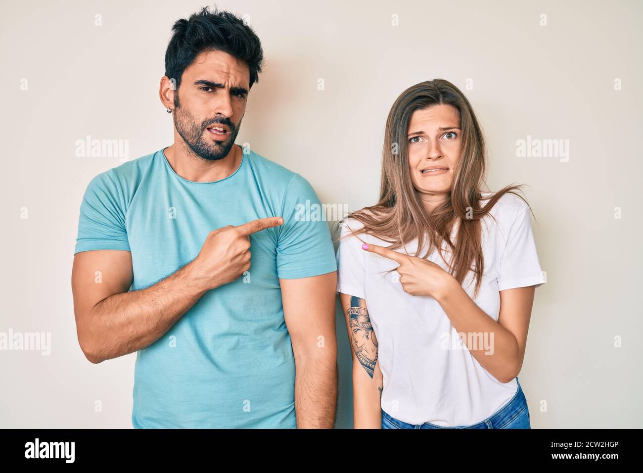 Beautiful young couple of boyfriend and girlfriend together pointing ...