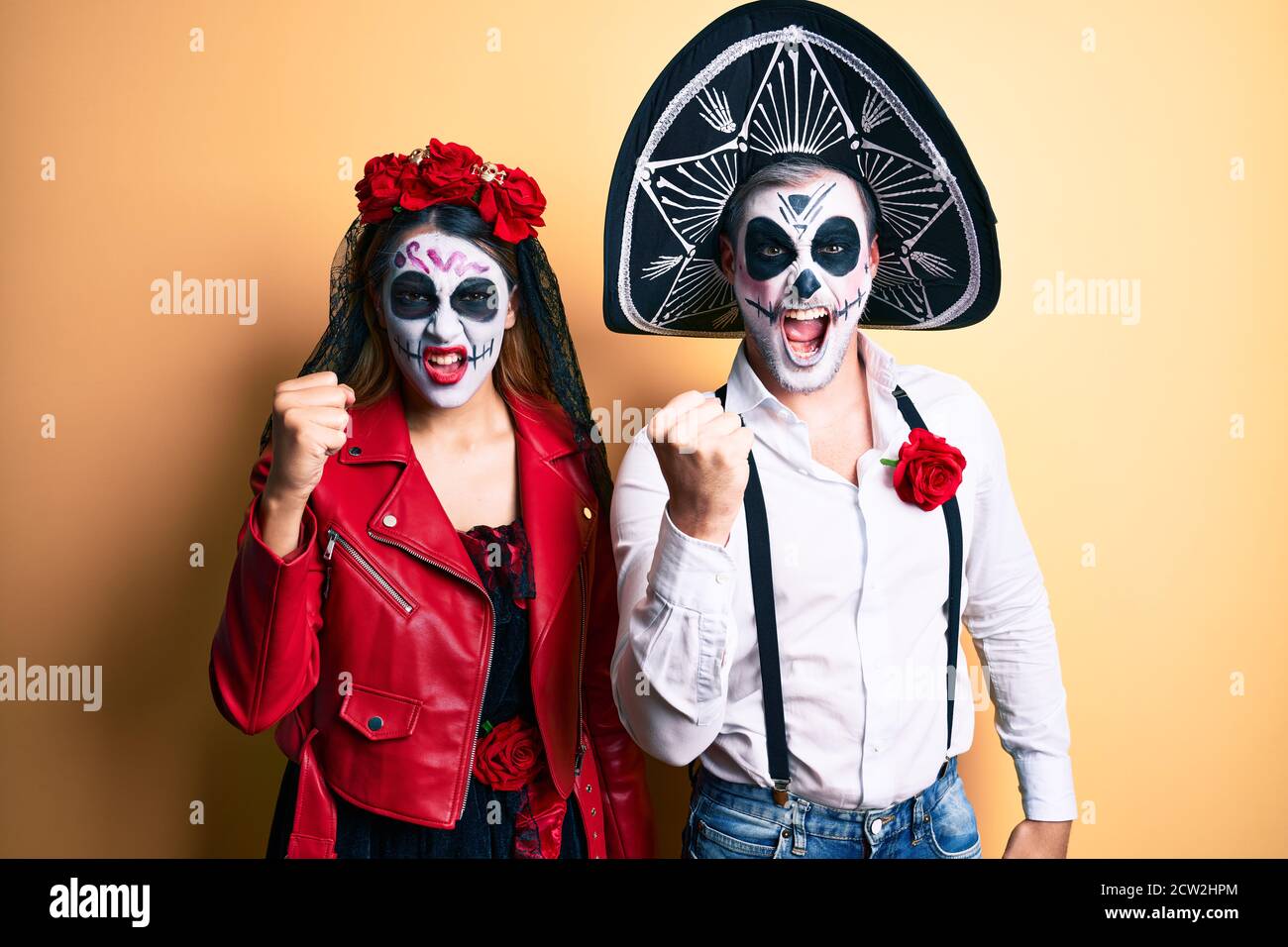 Couple wearing day of the dead costume over yellow angry and mad ...