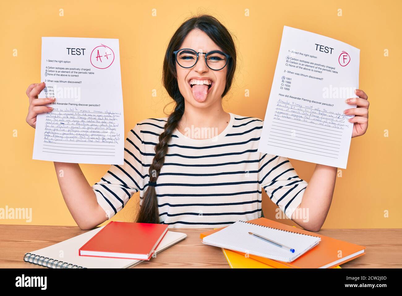 Brunette teenager girl showing failed and passed exam sticking tongue ...